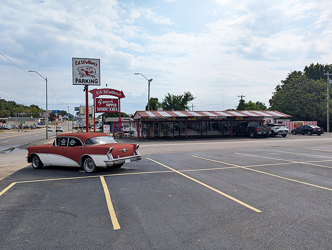 The classic red and white awning of Ed Walker's stands like a time portal to simpler days, complete with vintage car parking that feels absolutely right.