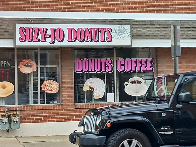 The pink neon promise of Suzy-Jo Donuts beckons from this unassuming Bridgeport storefront – proof that treasure doesn't always hide in fancy packaging.