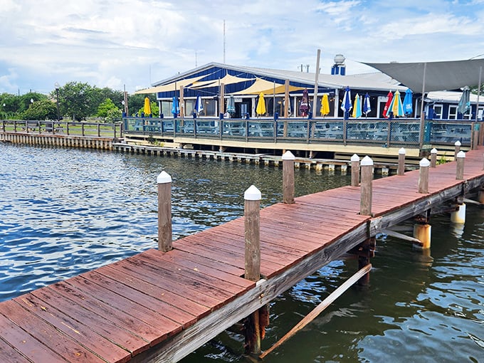 The journey to flavor paradise begins with a stroll down this wooden dock, where the water views are just the appetizer.
