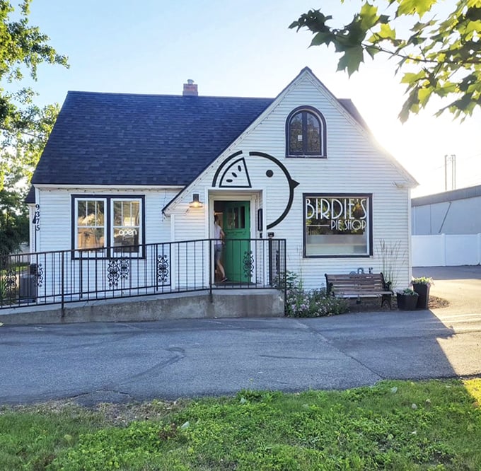A charming white cottage with a green door and Birdie's iconic pie-bird logo&mdash;like finding a storybook bakery hiding in plain sight.