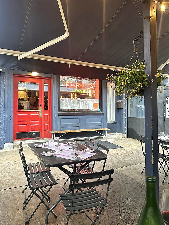 That red door against the blue-gray exterior is like finding the entrance to a secret Italian food society. The outdoor seating beckons with promises of pasta perfection.