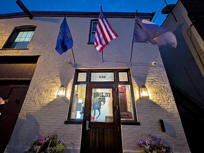 The unassuming white brick fa&ccedil;ade of Horse Inn glows with warm welcome at dusk, flags fluttering above like a secret culinary embassy in Lancaster.