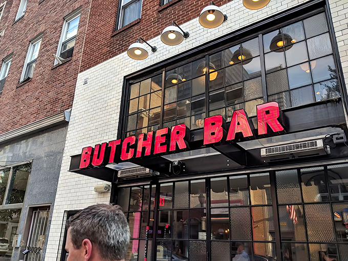 The neon-red "BUTCHER BAR" sign glows like a carnivore's North Star against white subway tile, beckoning meat lovers from across Philadelphia.