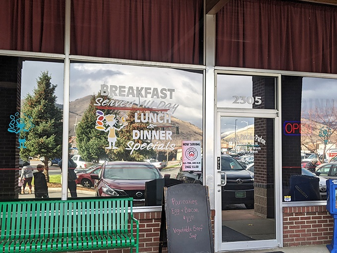 The green bench outside Paul's Pancake Parlor isn't just seating—it's the waiting room for Montana's breakfast faithful, where mountain views come standard with your pancake anticipation.
