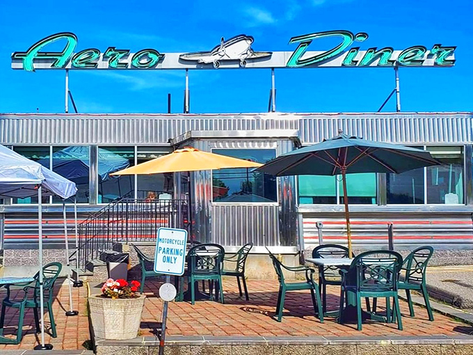 The gleaming chrome exterior of Aero Diner shines like a beacon for hungry travelers, complete with cheerful yellow umbrellas promising outdoor dining paradise.