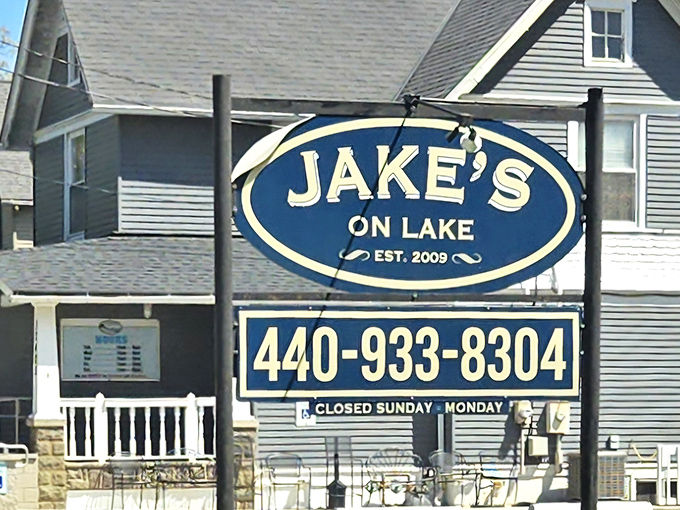 Jake's On Lake welcomes hungry travelers with its charming blue exterior and nautical sign, promising seafood treasures within this converted lakeside home.