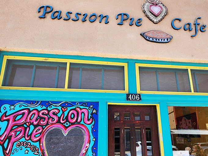 The vibrant turquoise and yellow trim frames Passion Pie Cafe like a desert jewel box, promising culinary treasures within.