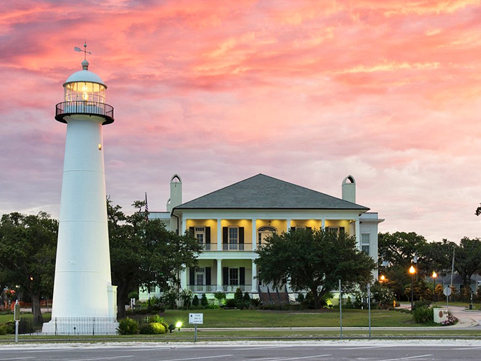 Nature's own light show competes with Biloxi's historic beacon as sunset paints the sky in impossible pinks.
