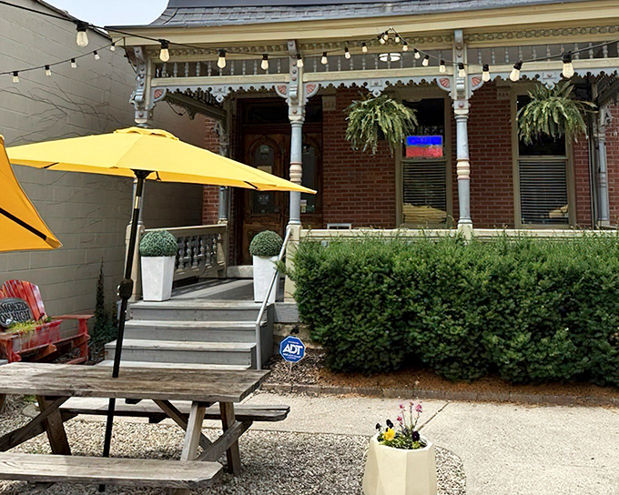 BBQ paradise found! Picnic tables await beneath the watchful gaze of a historic porch where smoke signals have replaced Victorian tea time.