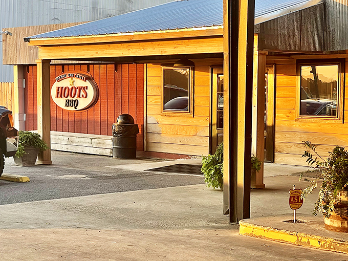 The wooden facade of Hoot's BBQ glows like a beacon of smoky promise in the golden hour light.