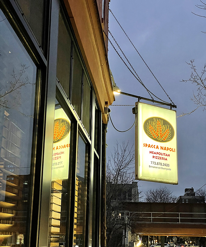 The glowing sign of Spacca Napoli beckons hungry passersby on a dusky Chicago evening, promising a slice of authentic Neapolitan warmth within.