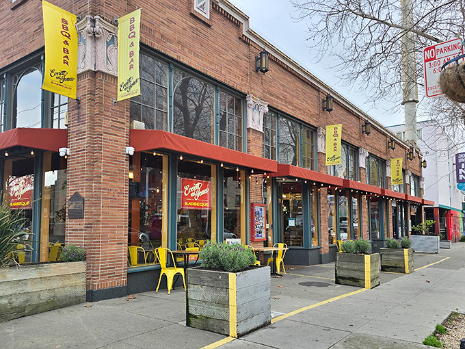Yellow banners flutter like smoke signals to hungry passersby, promising the kind of barbecue that makes vegetarians question their life choices.