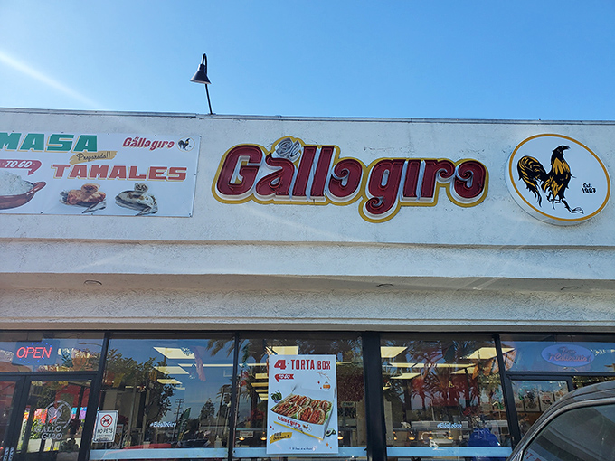 The iconic rooster logo watches over El Gallo Giro's exterior, where culinary treasures await beneath the California sun.