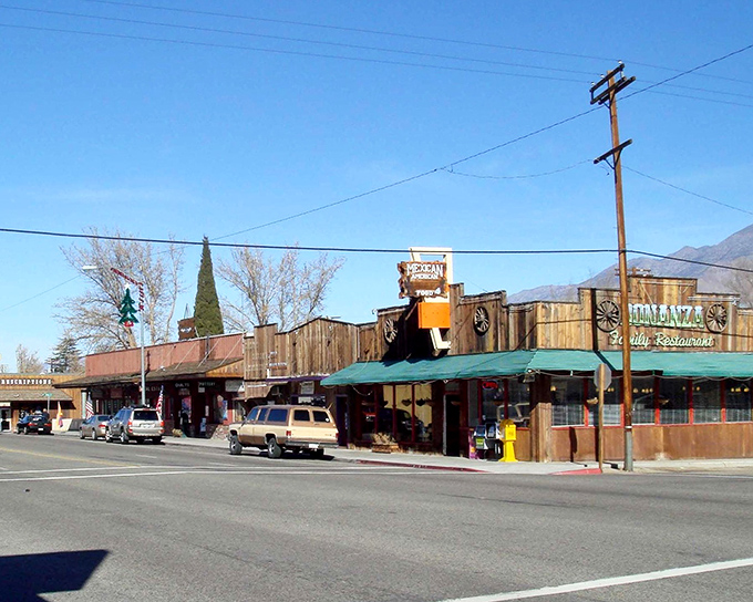Where Western dreams meet Eastern Sierra reality. The Bonanza Mexican Restaurant stands as a wooden sentinel against the backdrop of California's mightiest peaks.