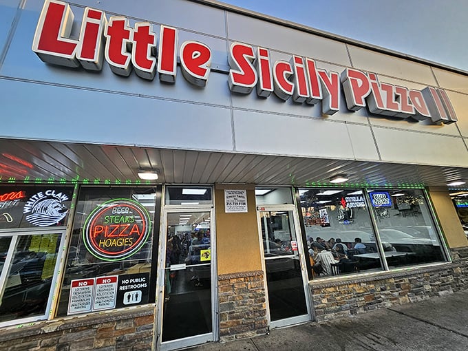 The unassuming storefront of Little Sicily Pizza II, where culinary magic happens behind that simple red signage and stone facade.
