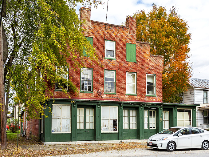 Historic brick buildings with green trim stand as time capsules in Clifton, where autumn leaves frame architecture that whispers stories of Ohio's past.