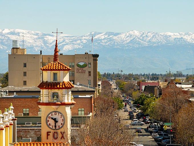 Visalia's iconic Fox Theatre clock tower stands sentinel over downtown, with the majestic Sierra Nevada mountains creating a backdrop worthy of a Hollywood establishing shot.