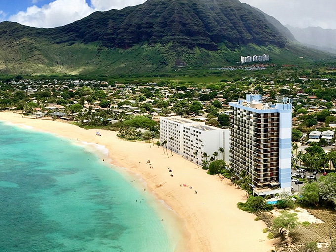 Makaha Beach stretches out like nature's welcome mat, where turquoise waters meet golden sands beneath the watchful gaze of ancient mountains.