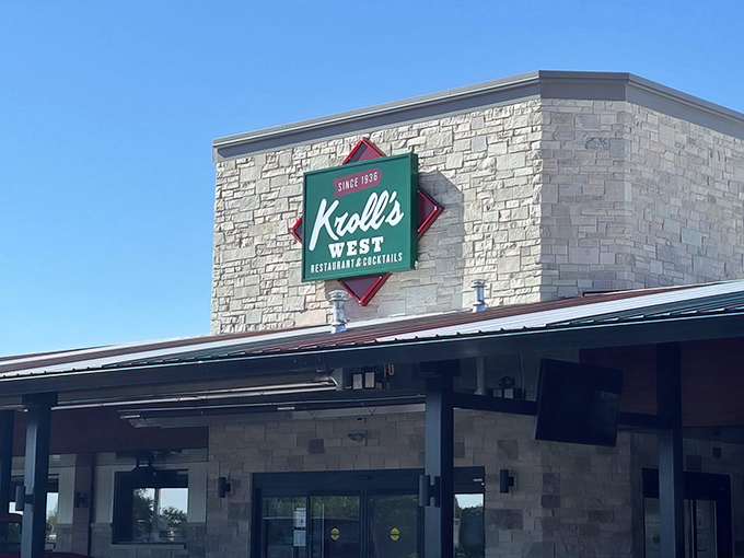 The iconic green and red Kroll's West sign stands proudly against a blue Wisconsin sky, beckoning hungry Packers fans and comfort food enthusiasts alike.