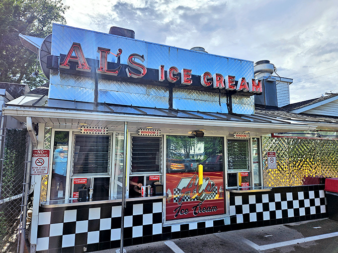 The iconic red "AL'S ICE CREAM" sign beckons like a neon lighthouse, guiding hungry travelers to this South Burlington landmark that time forgot&mdash;gloriously so.
