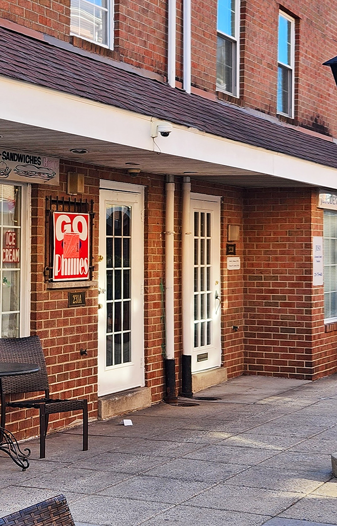The unassuming brick exterior of Gooey Looies might not scream "food paradise," but that "Go Phillies" sign tells you everything about its authentic Philly soul.