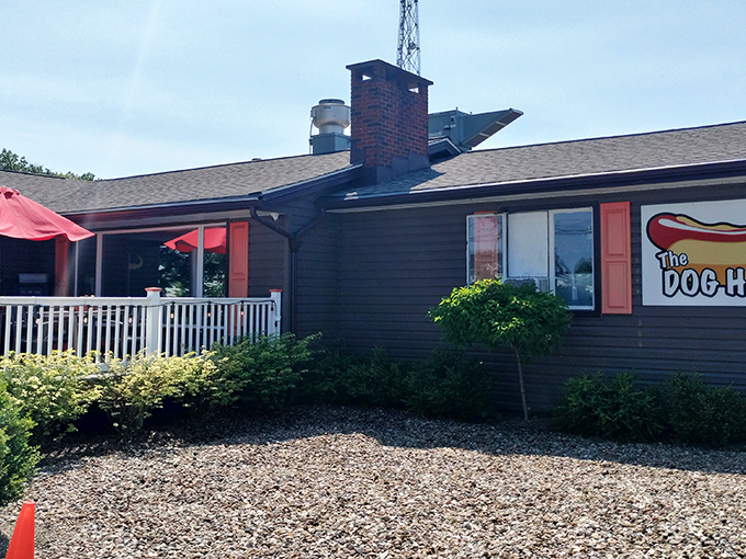 The Cleveland Dog House welcomes hungry travelers with its charming ranch-style exterior and bright red umbrellas on the patio.