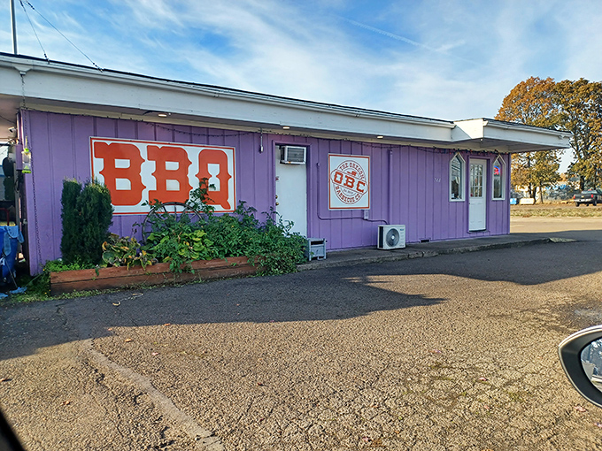 That bold BBQ sign isn't just decoration &ndash; it's truth in advertising. This humble purple building houses smoke masters who know their craft.