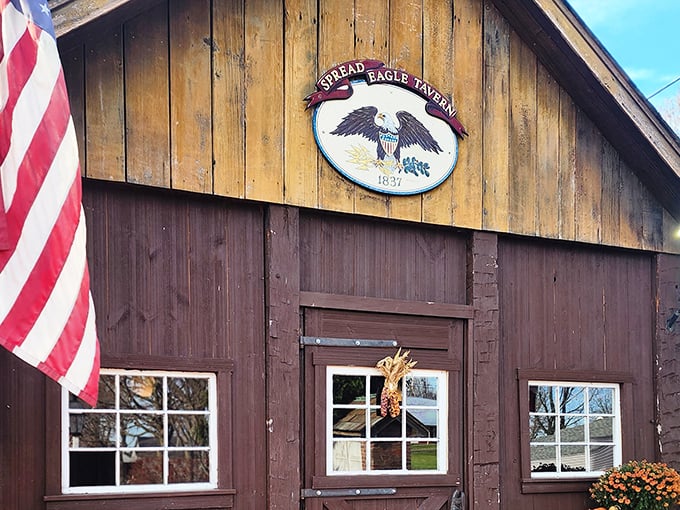 The Spread Eagle Tavern sign proudly displays its heritage, with an American flag waving a warm welcome to hungry travelers.