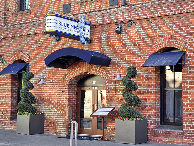 The historic brick facade of Blue Mermaid welcomes seafood lovers with nautical charm and those perfectly manicured spiral topiaries standing guard like maritime sentinels.