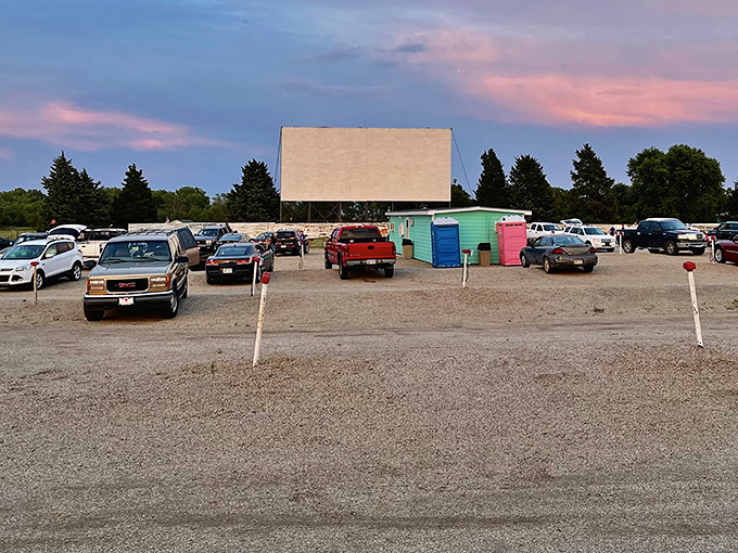 Twilight magic unfolds as vehicles gather before the towering screen, a perfect Kansas evening where memories are made under pastel skies.