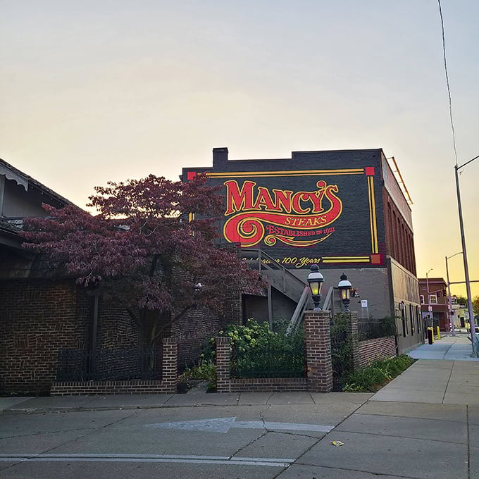 The iconic red Mancy's sign glows like a beacon for hungry Toledoans, promising carnivorous delights within those brick walls.
