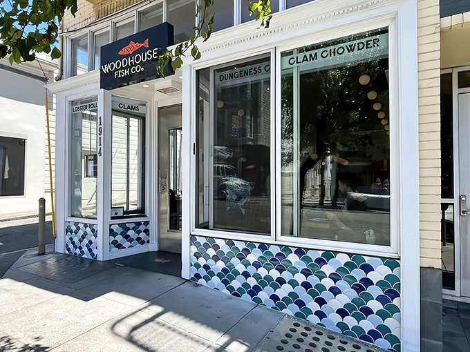The maritime charm begins before you even step inside, with Woodhouse Fish Co.'s distinctive blue-and-white fish scale tiles framing a storefront that practically shouts "lobster rolls inside!"
