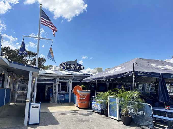 The iconic blue exterior of The Starboard welcomes beach-goers with its giant orange crush cup standing guard like a citrusy sentinel of summer fun.