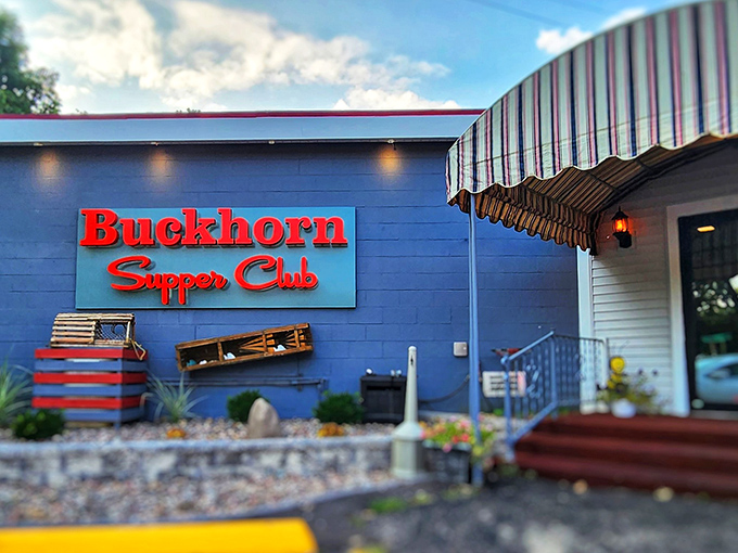 The iconic red Buckhorn Supper Club sign against the blue-gray exterior promises the kind of Wisconsin dining experience that makes vegetarians question their life choices.