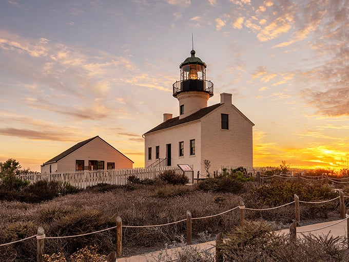 Sunset transforms the lighthouse into a watercolor painting come to life, golden light bathing its historic walls as day surrenders to evening.