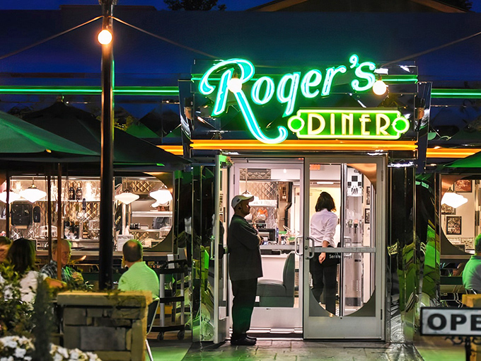 As night falls, Roger's neon sign transforms into a beacon of culinary hope, glowing with the promise of late-night comfort that would make James Dean proud.