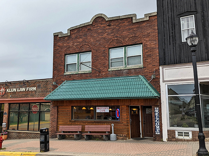 The classic brick fa&ccedil;ade of Britton's Caf&eacute; stands as a beacon of breakfast hope on Ely's main street, complete with welcoming wooden benches for post-pancake contemplation.