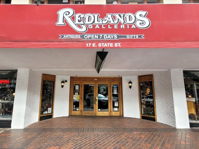 The iconic red awning of Redlands Galleria beckons like a time portal, complete with an antique flower cart that practically whispers, "Come in, the past is waiting."
