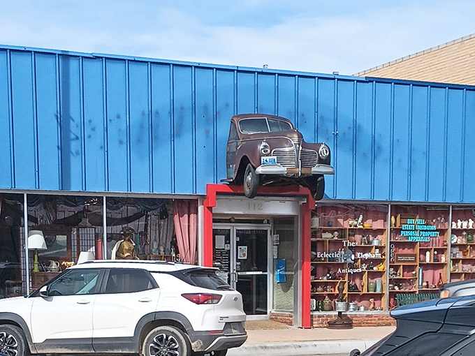 That vintage Plymouth perched above the entrance isn't just decoration&mdash;it's a promise of the automotive treasures waiting inside this teal time capsule.