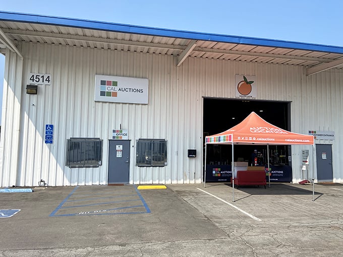 The unassuming exterior of Cal Auctions in San Diego &ndash; where treasure hunting begins beneath that bright orange tent and metal siding.