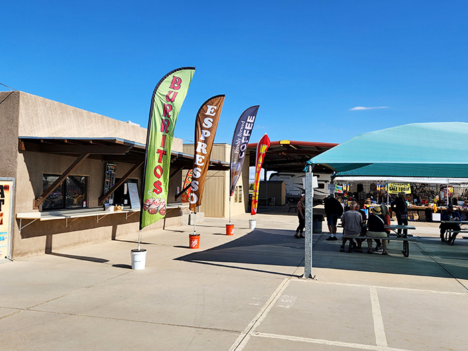 Colorful banners welcome shoppers to Arizona Market Place, where the promise of deals flutters in the desert breeze.