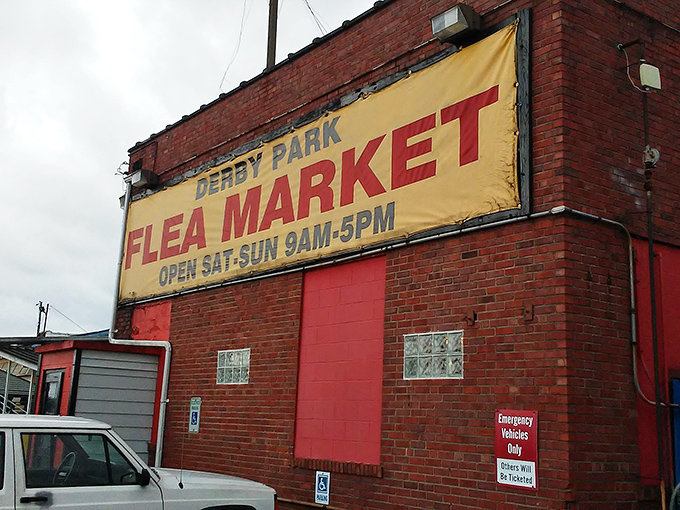 The iconic red brick building with its weathered yellow banner promises weekend treasure hunting adventures from 9AM-5PM. No frills, all thrills!