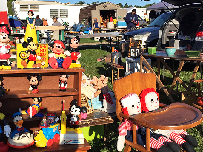 Treasure hunters browse under blue canopies while vintage bicycles wait for their next adventure. Every aisle promises unexpected discoveries.