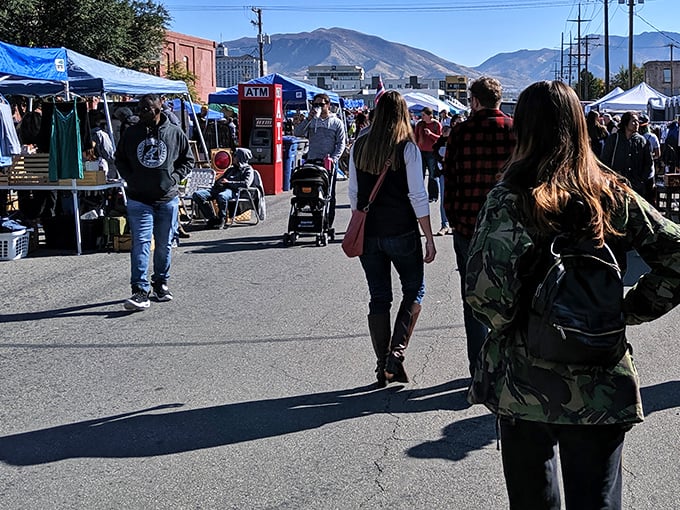 The Urban Flea Market stretches toward the mountains, where treasure hunters navigate a sea of blue tents and possibilities on a perfect Utah morning.