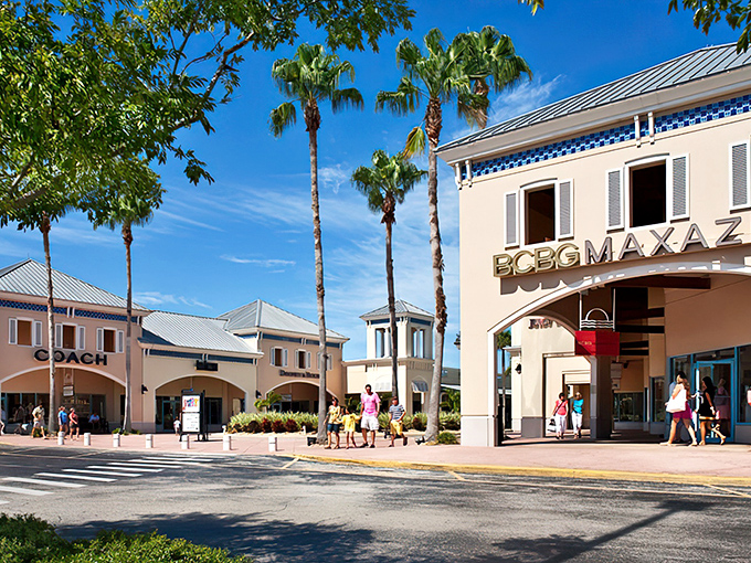 Palm trees stand guard at the entrance to shopping paradise, where Florida sunshine meets designer discounts in perfect retail harmony.