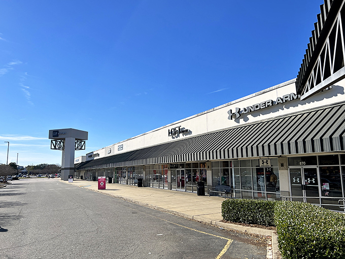 The Under Armour storefront beckons like a siren song to bargain hunters. Blue skies above promise good fortune for those brave enough to venture inside.