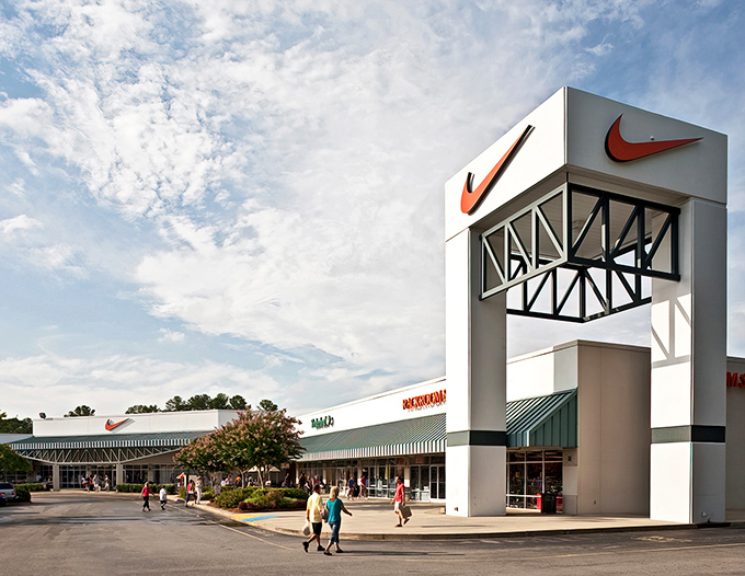 The iconic Nike tower stands tall against Carolina blue skies, beckoning bargain hunters like a retail lighthouse guiding ships to discount shores.