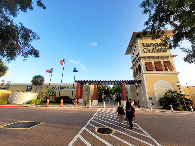 Wide, welcoming walkways lined with manicured greenery make Tanger Outlets feel more like a resort than a shopping destination. Levi's and Adidas beckon with promises of deals.