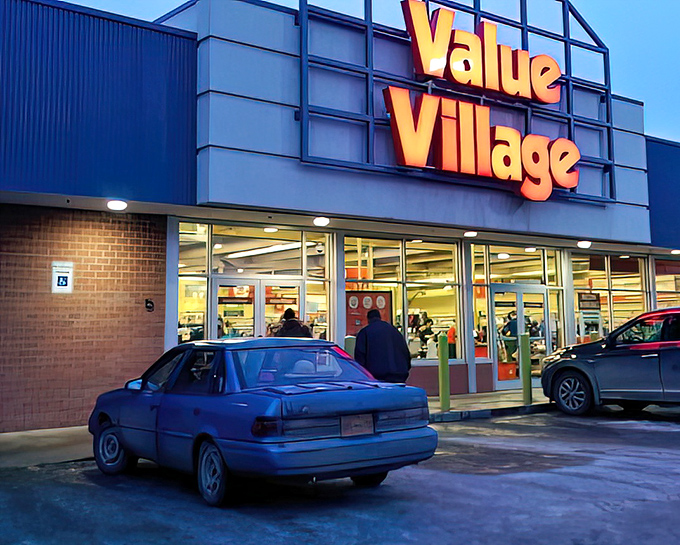 As dusk falls, the illuminated Value Village sign becomes a beacon for night owls seeking last-minute treasures before closing time.