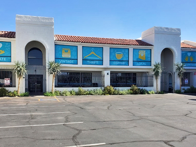 The Southwest-style facade of Thrift to Thrive beckons with colorful blue signs promising vintage treasures, coffee, and local finds behind those wrought iron gates.